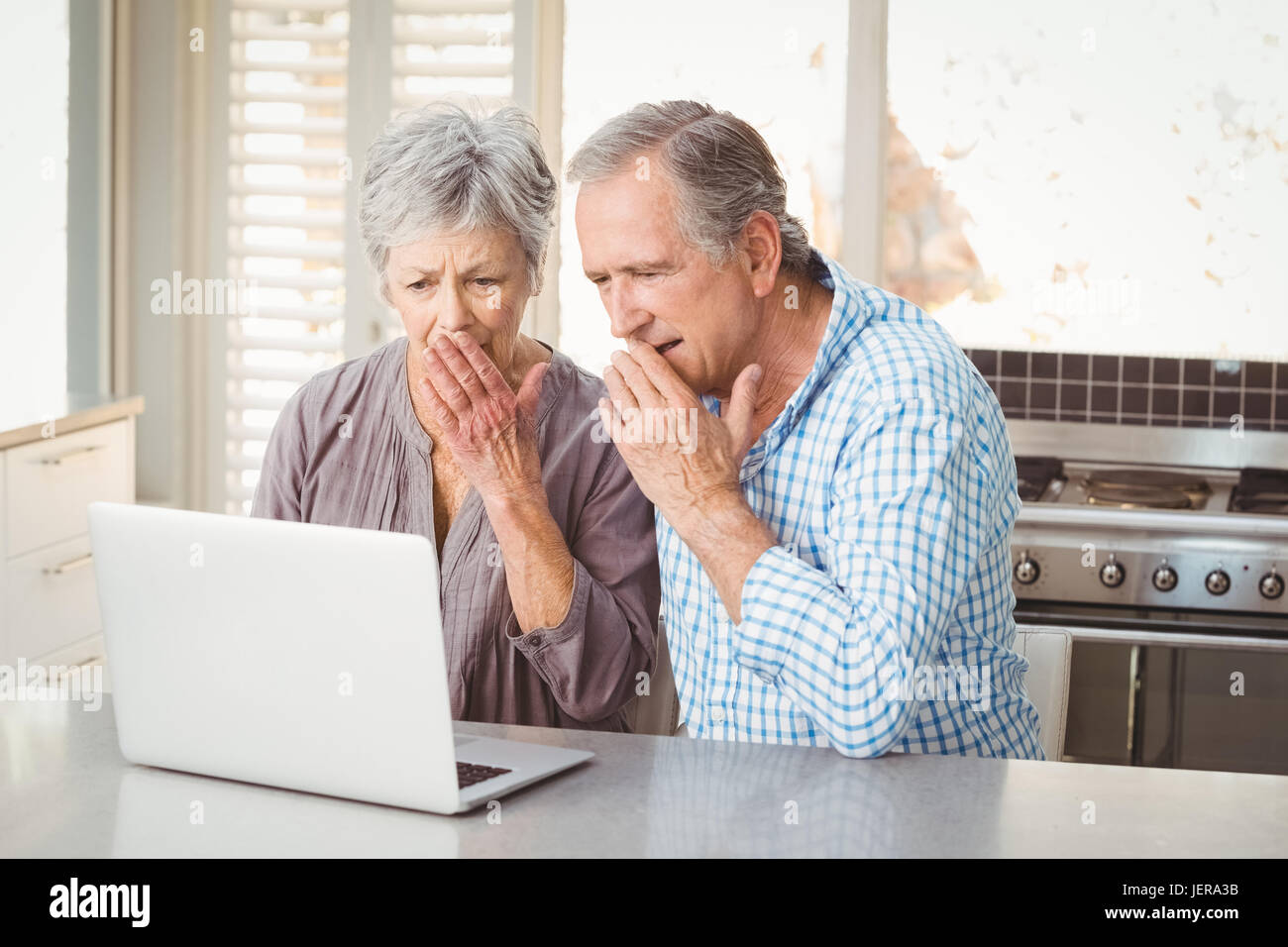 Shocked senior couple looking at laptop Stock Photo - Alamy