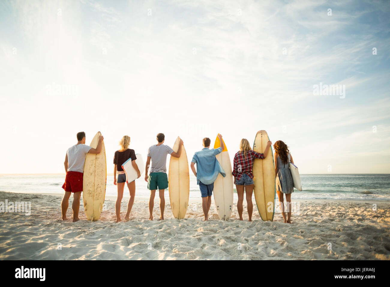 Friends holding surfboard on the beach Stock Photo - Alamy