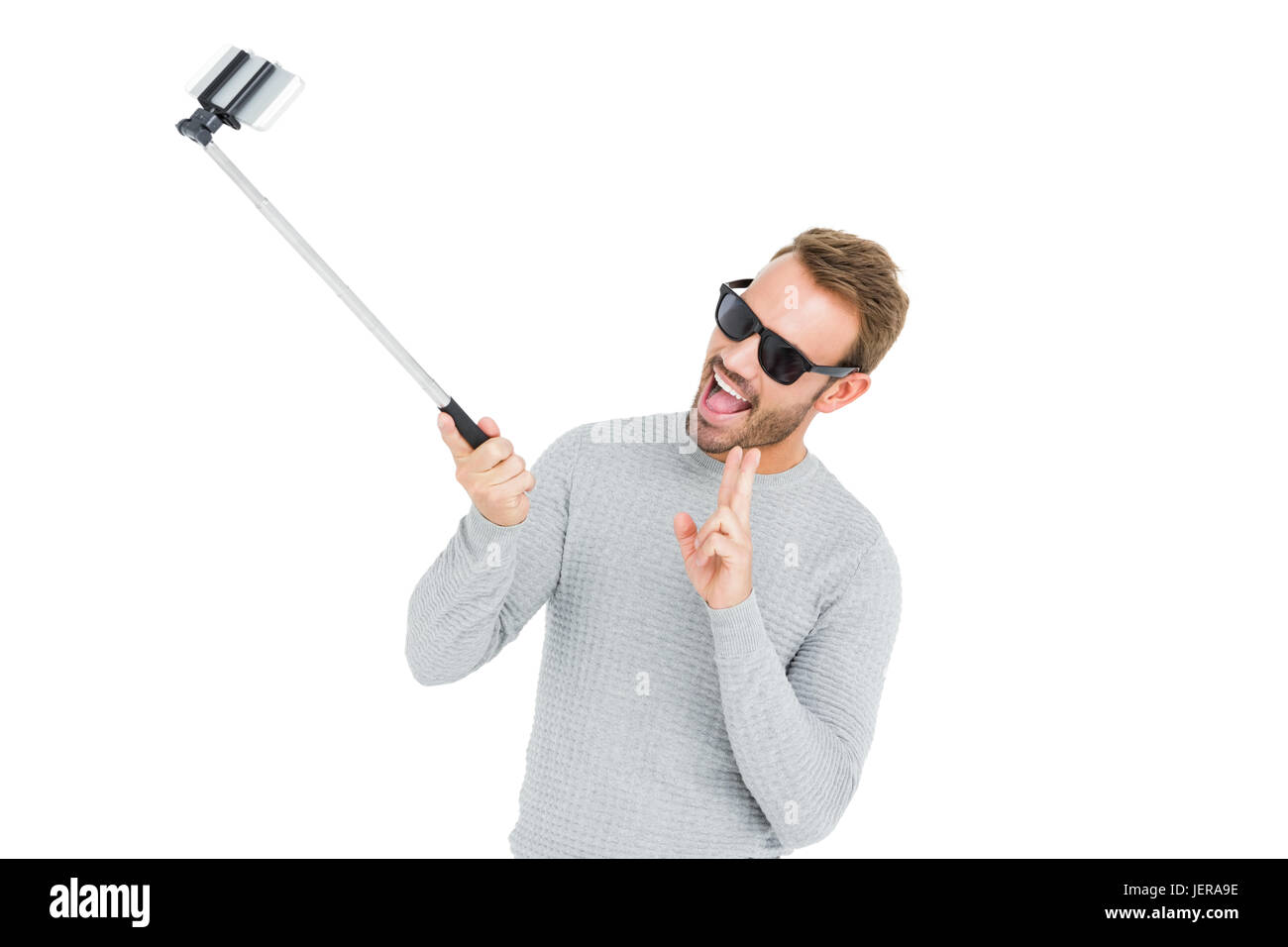 Young man taking a selfie with selfie stick Stock Photo - Alamy
