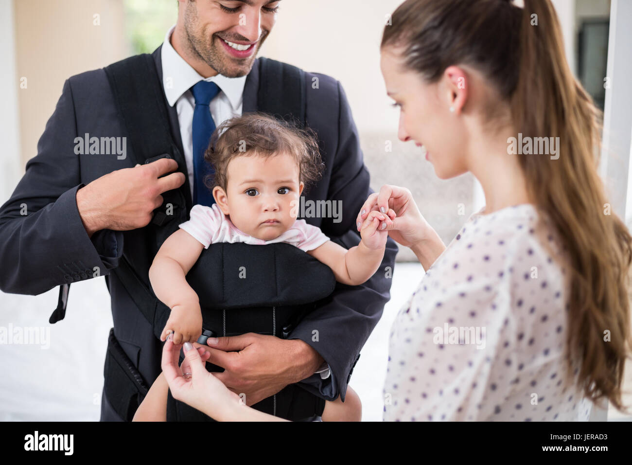Smiling father carrying baby with mother Stock Photo - Alamy