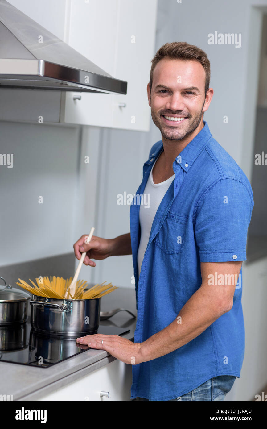 Young man cooking spaghetti Stock Photo - Alamy