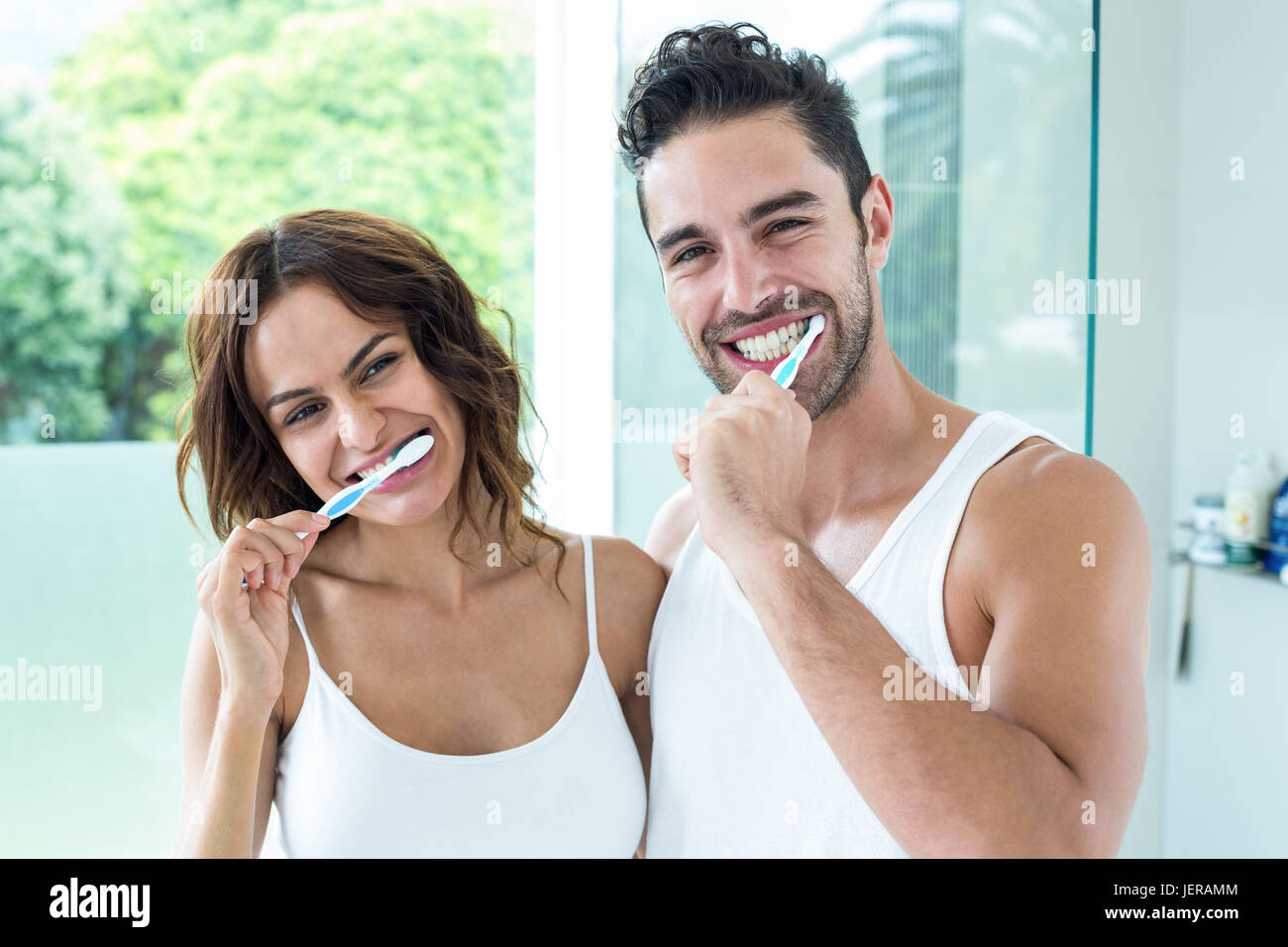 Happy young couple brushing teeth Stock Photo - Alamy