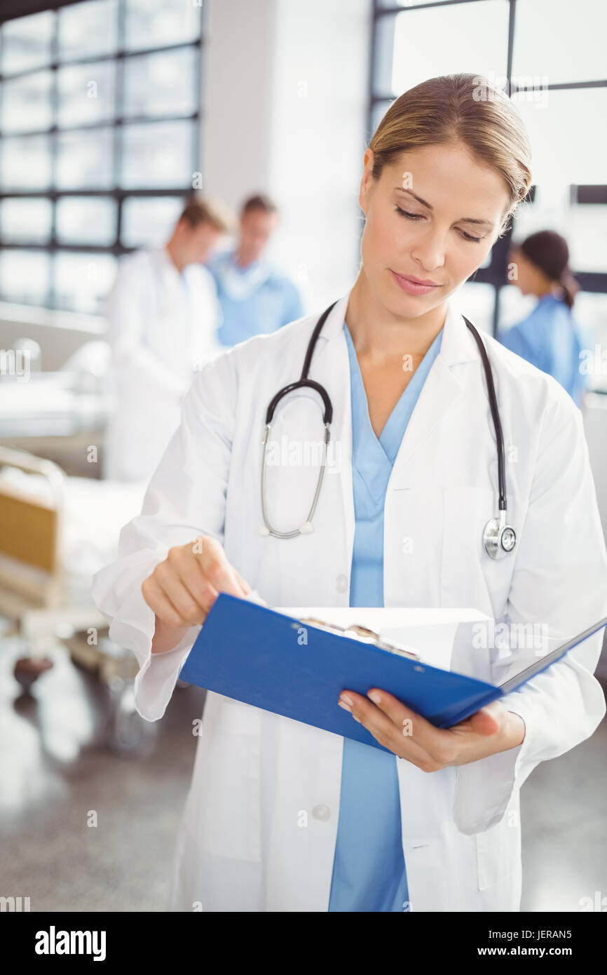 Female doctor looking at medical report Stock Photo - Alamy