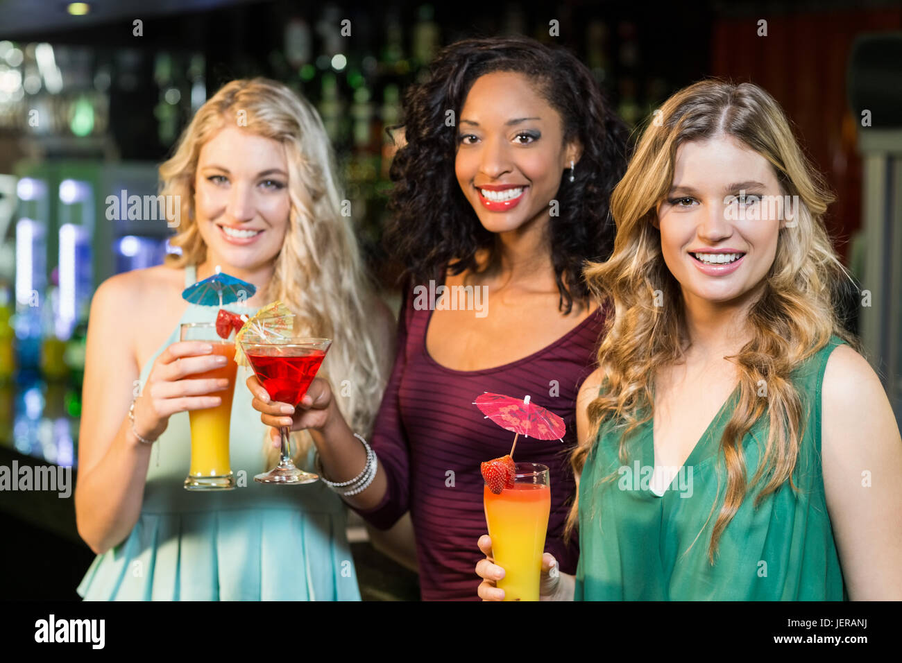 Happy friends drinking cocktails Stock Photo - Alamy