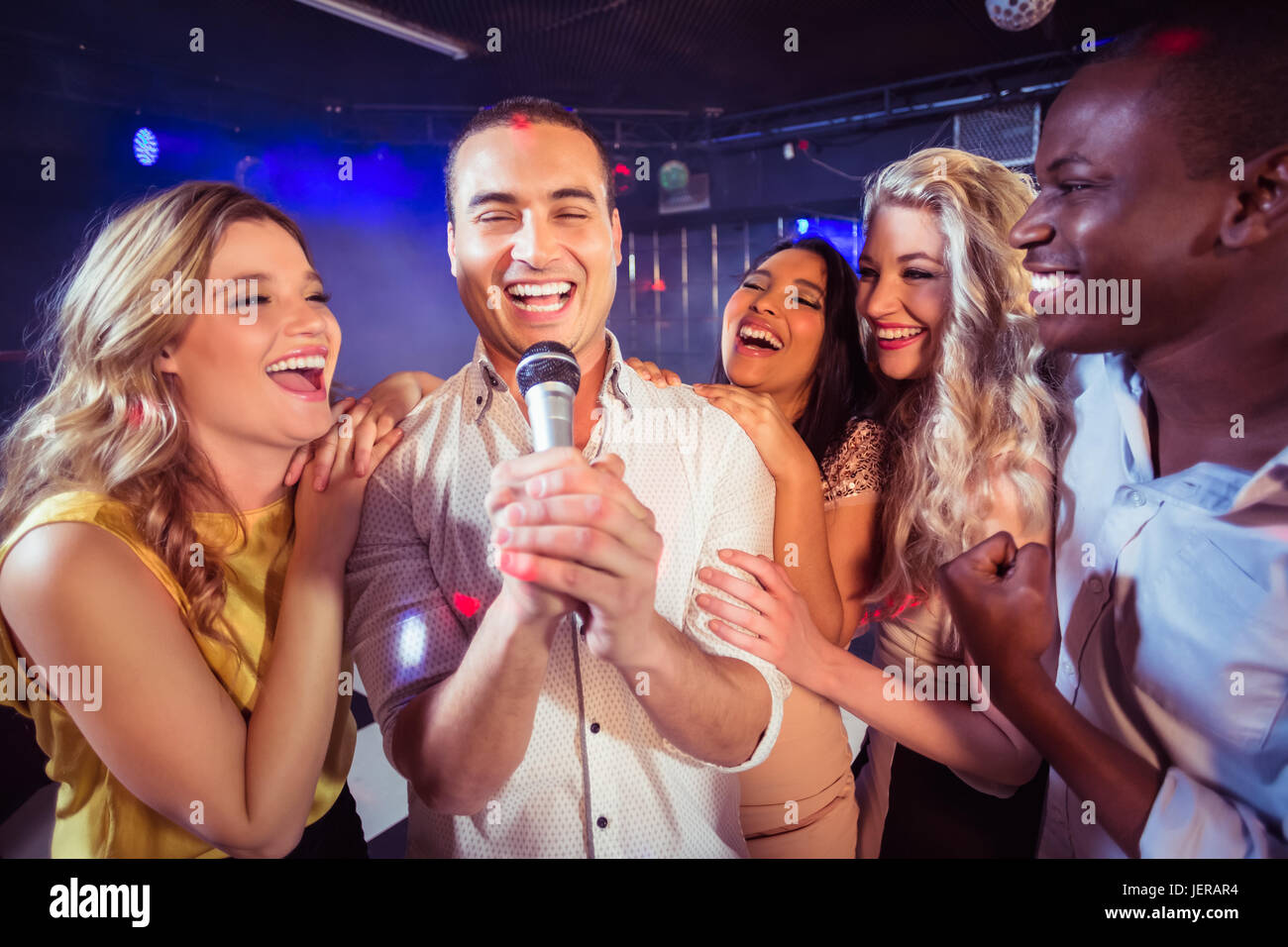 Happy friends singing at the karaoke Stock Photo - Alamy