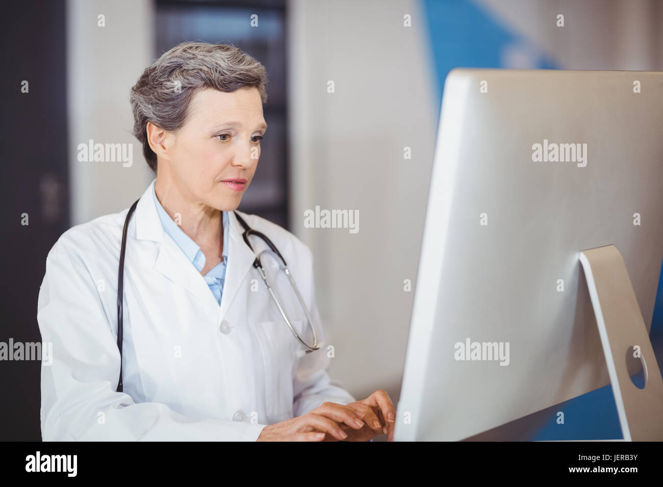 Doctor working at computer desk Stock Photo - Alamy