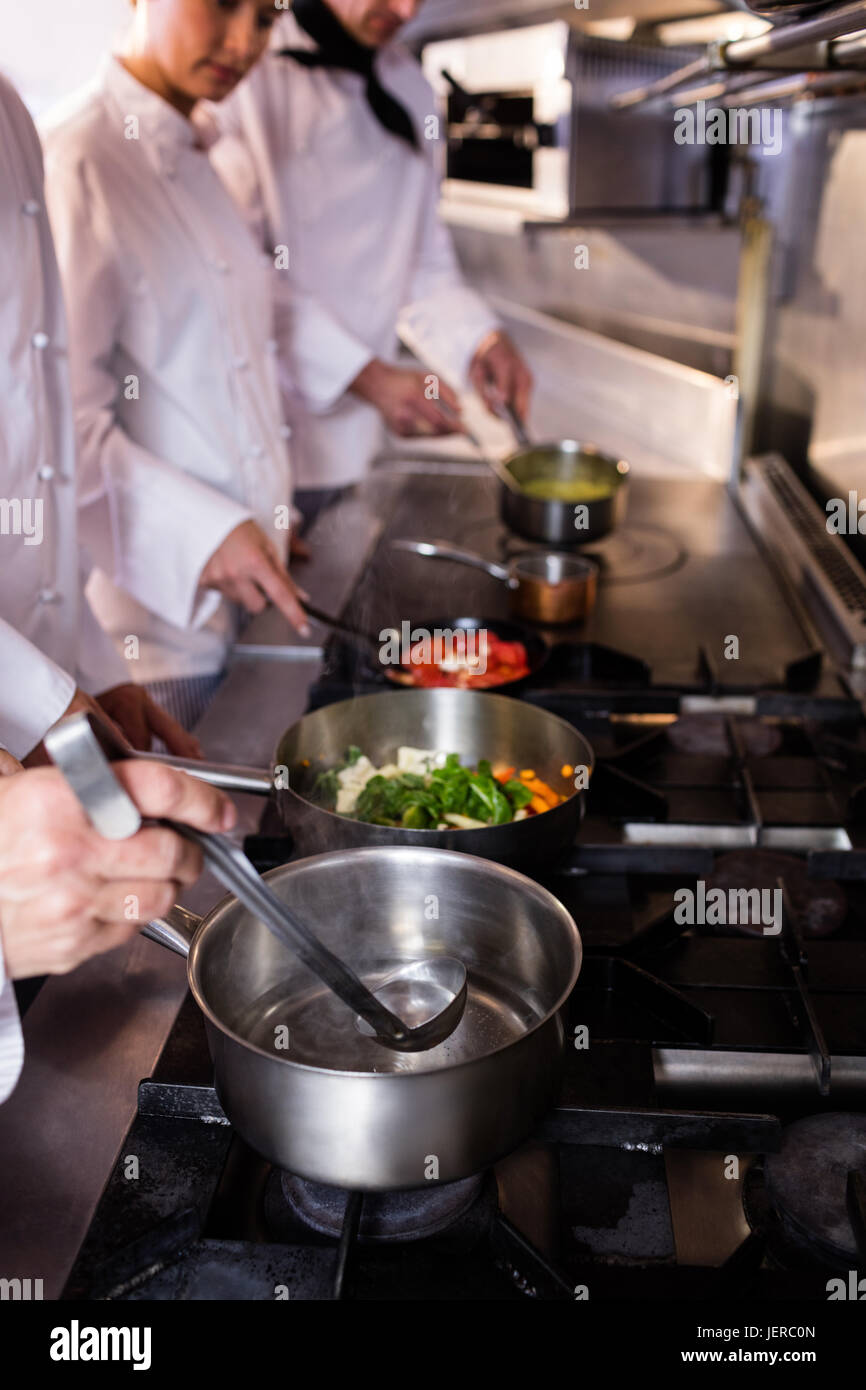 Group of chef preparing food in the kitchen Stock Photo - Alamy