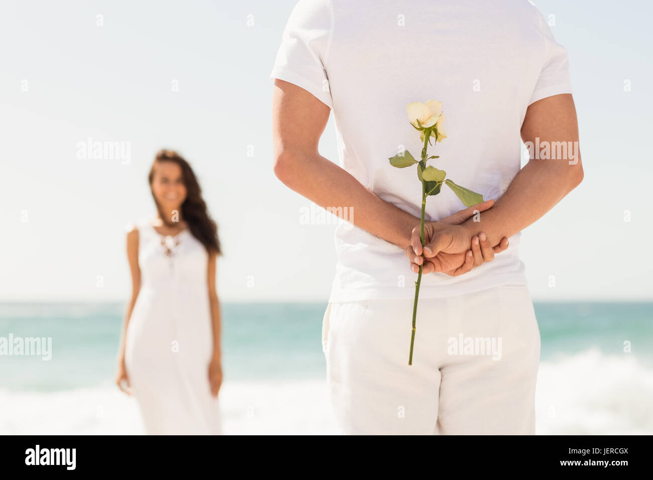 Boyfriend holding rose behind his back Stock Photo - Alamy