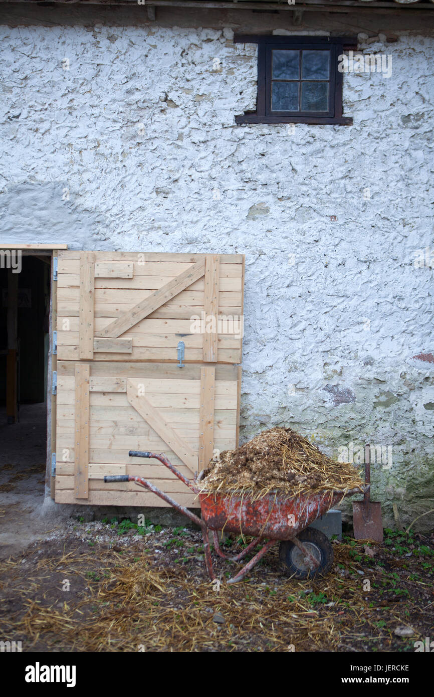 Wheelbarrow in front of barn Stock Photo - Alamy