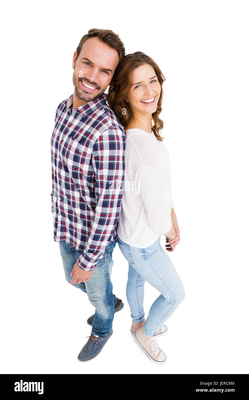 Happy young couple standing back to back Stock Photo - Alamy