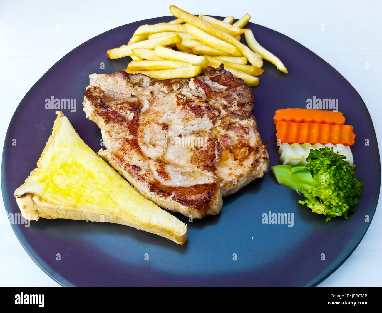 grilled pork chop (neck cut) with bread and french fries Stock Photo ...
