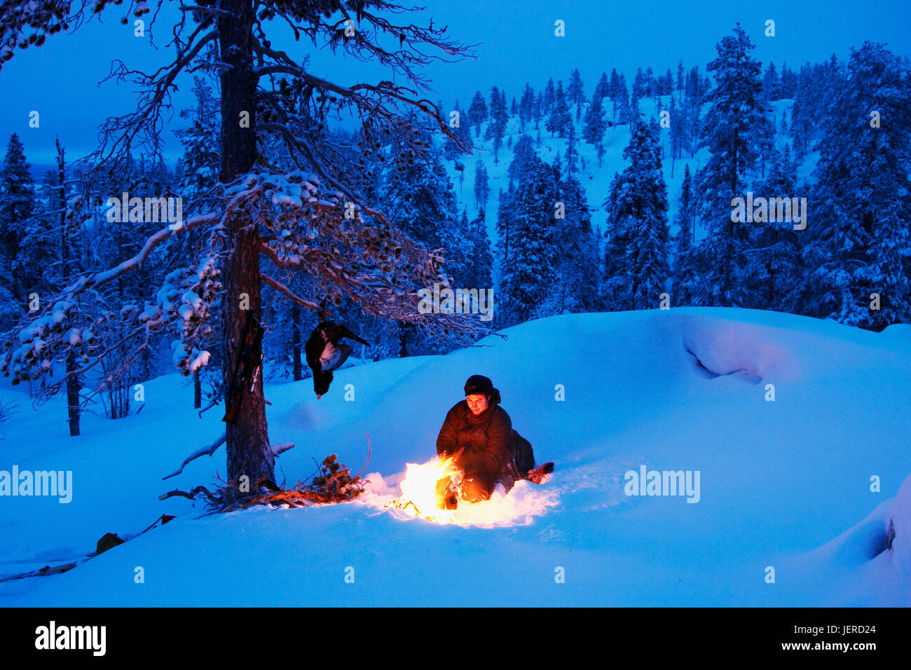 Hunter having fire at dusk Stock Photo - Alamy