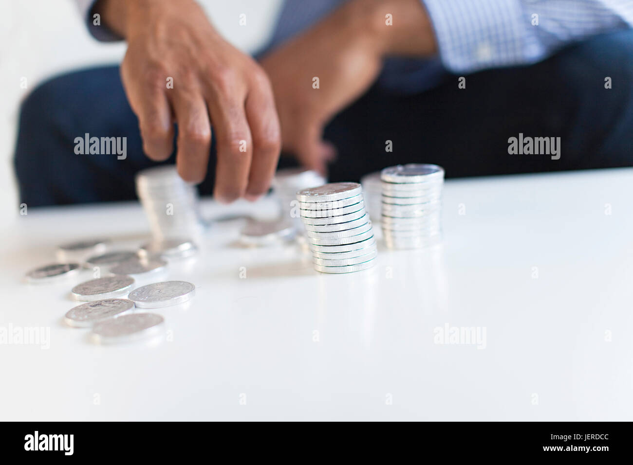 Businessman stacking coins in hi-res stock photography and images - Alamy