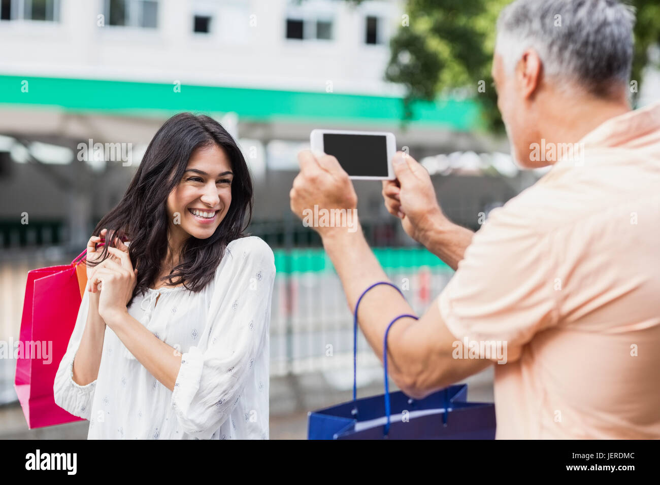 Man photographing woman with shopping bag Stock Photo - Alamy