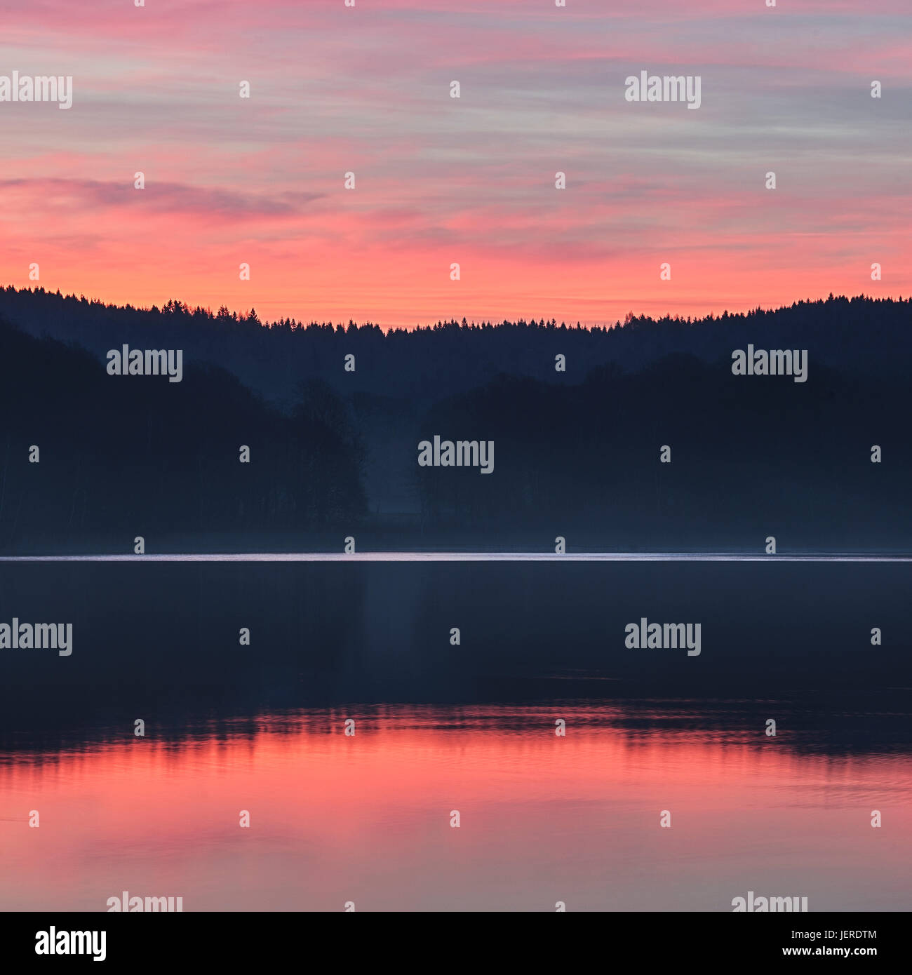 Sunset over forest Stock Photo - Alamy