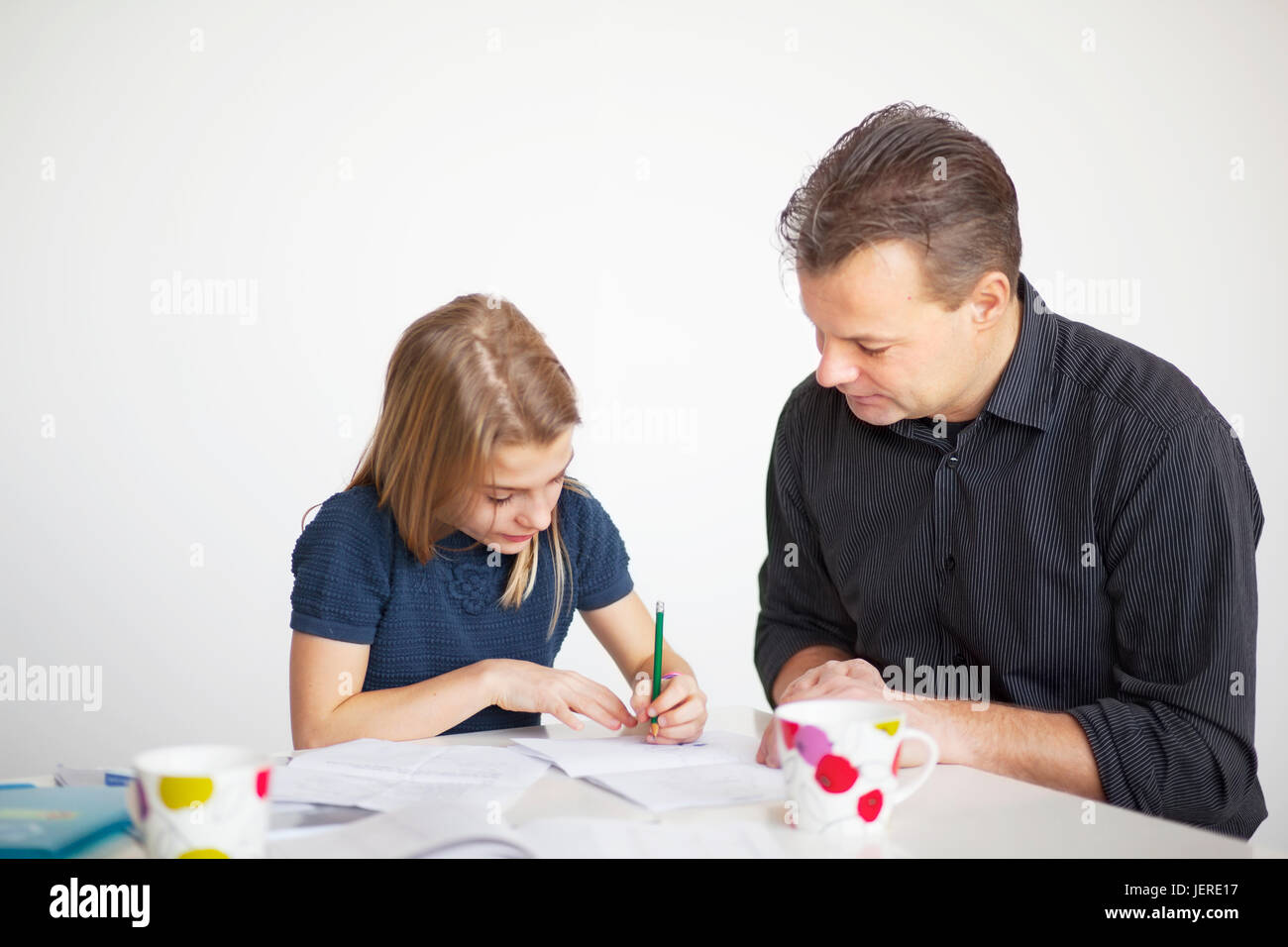Father helping daughter with homework Stock Photo - Alamy