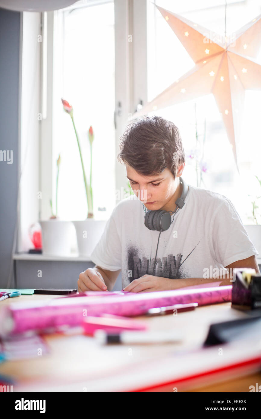 Teenage boy wrapping present Stock Photo - Alamy