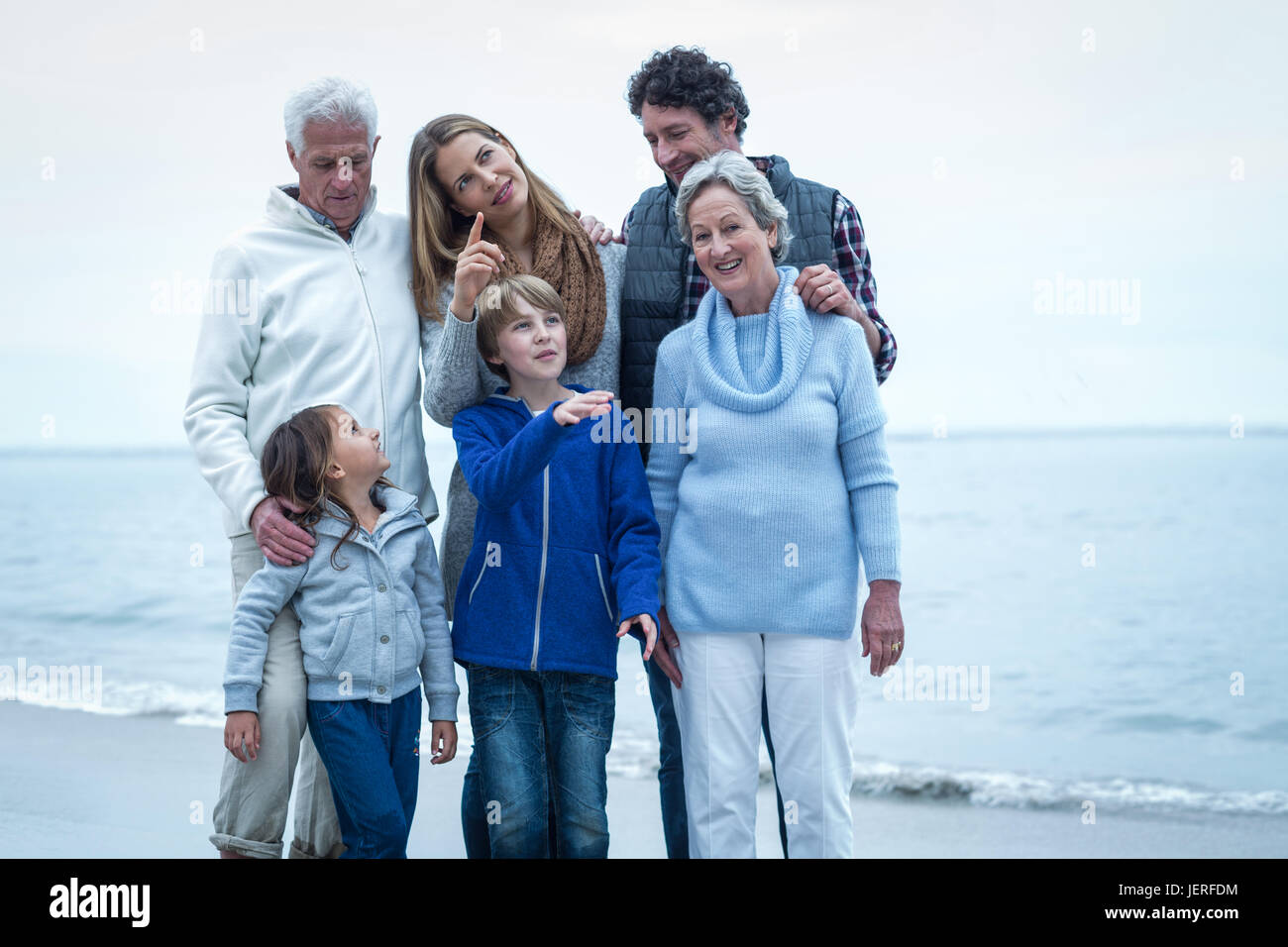 Happy family standing at beach Stock Photo - Alamy