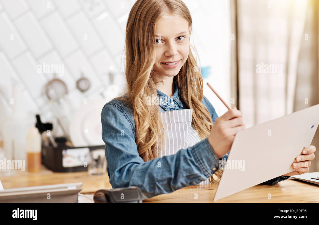 Charming teenage girl making notes in a menu Stock Photo - Alamy