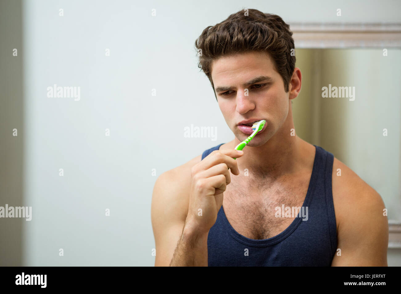 Young man brushing his teeth in bathroom Stock Photo - Alamy
