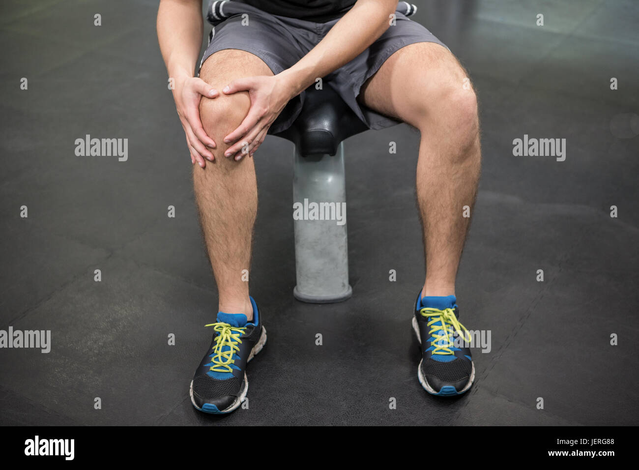 Man with an injured knee sitting in gym Stock Photo - Alamy