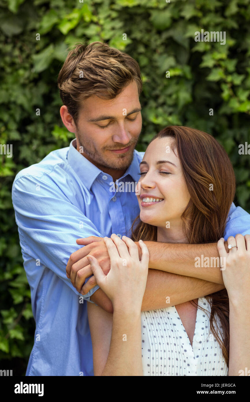 Smiling couple hugging at front yard Stock Photo - Alamy