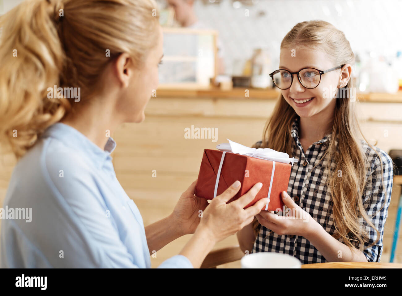 Charming teenage girl being happy to get a present Stock Photo - Alamy