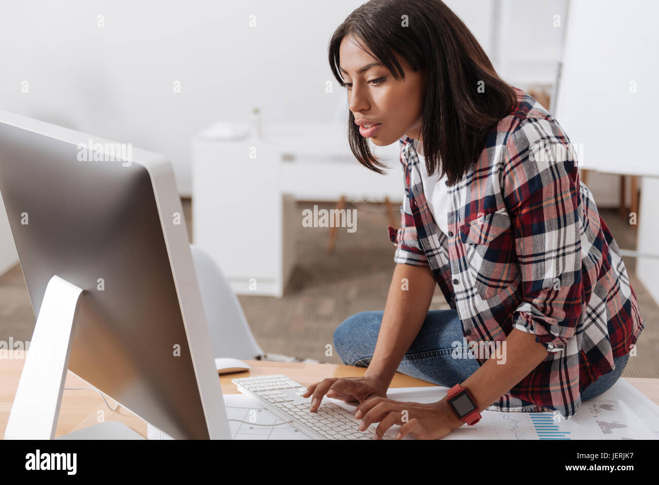 Nice serious woman looking at the computer screen Stock Photo - Alamy