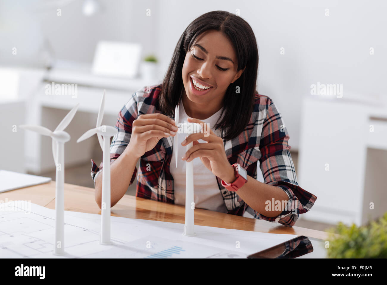 Positive beautiful woman holding a windmill model Stock Photo - Alamy
