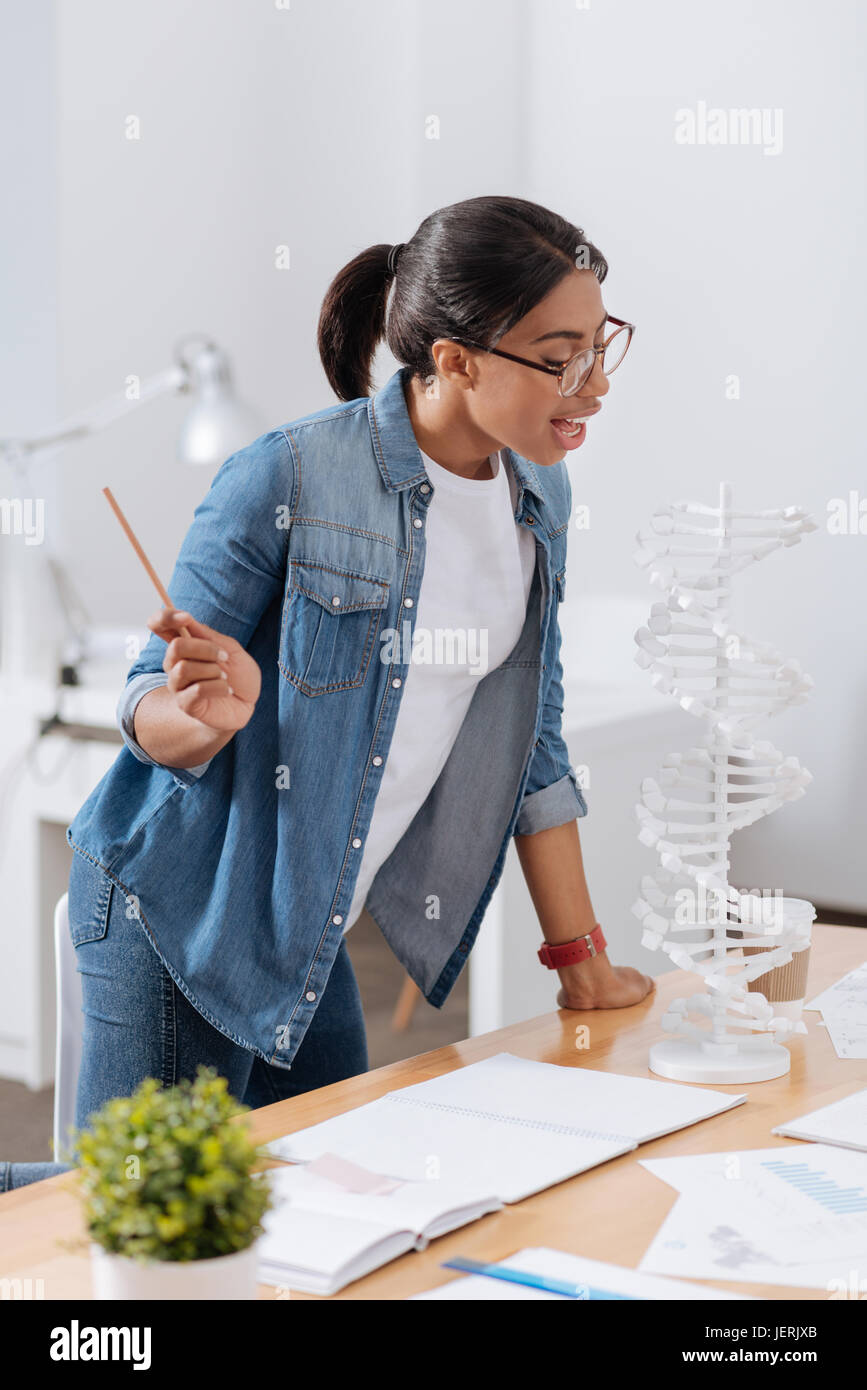 Intelligent smart woman looking at the gene model Stock Photo - Alamy