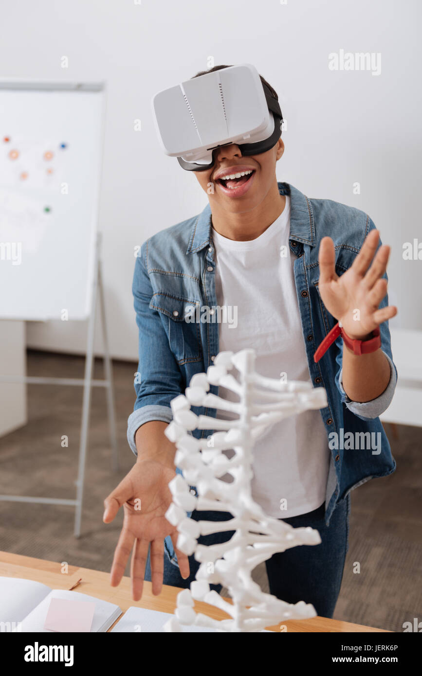 Happy positive student showing a DNA model Stock Photo - Alamy
