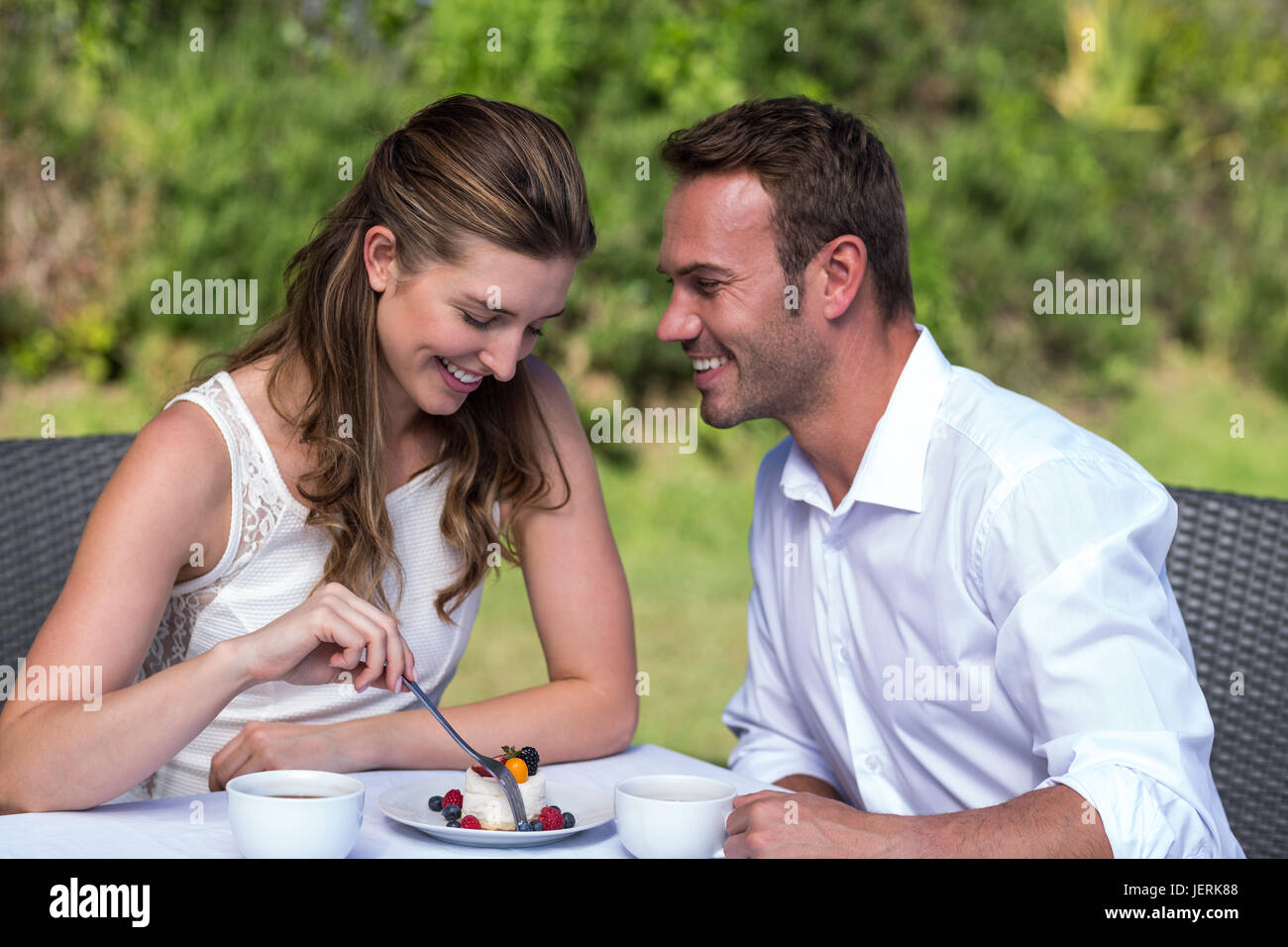 Happy couple sitting in park Stock Photo - Alamy