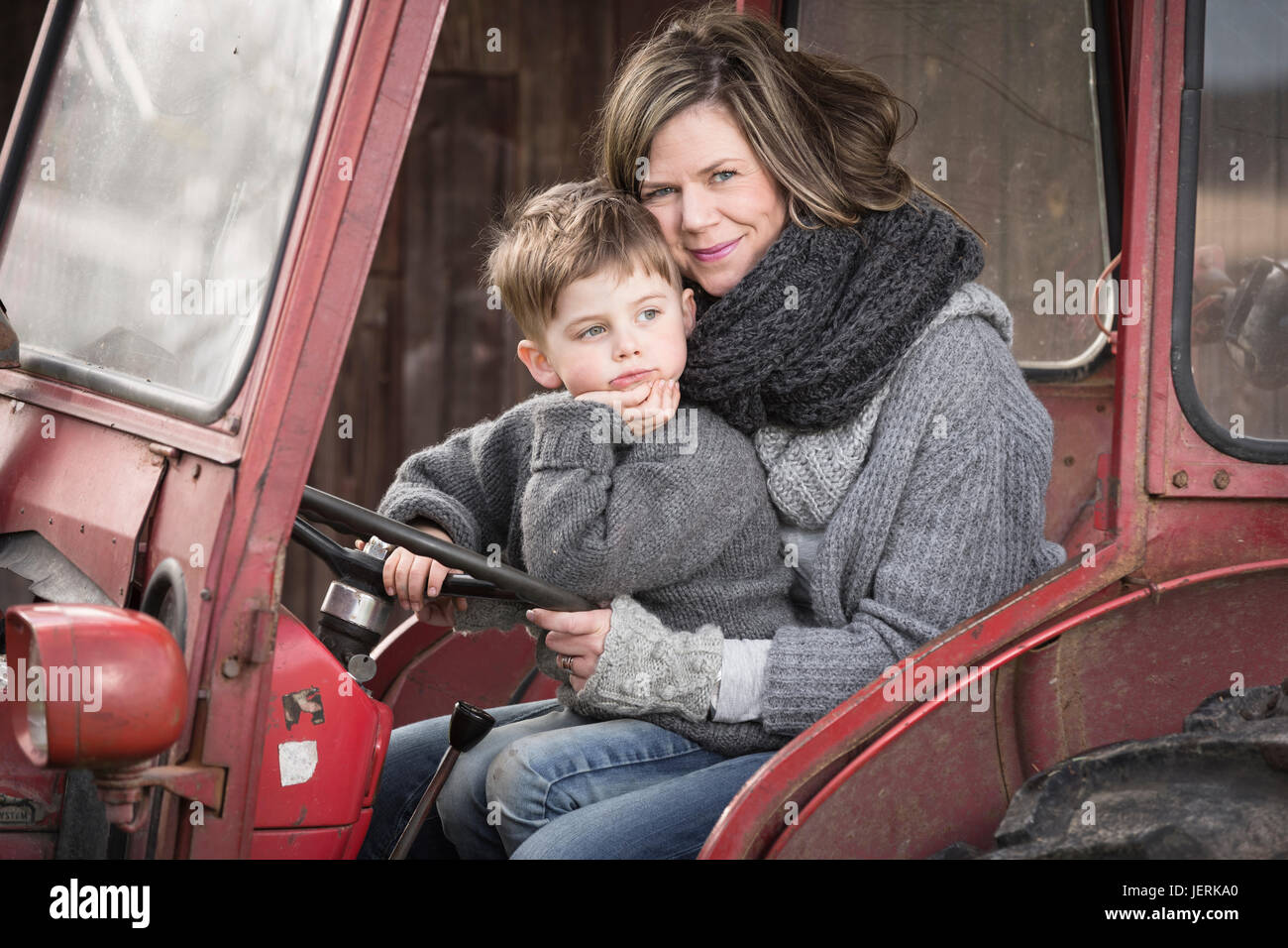 Woman with son sitting in tractor Stock Photo - Alamy