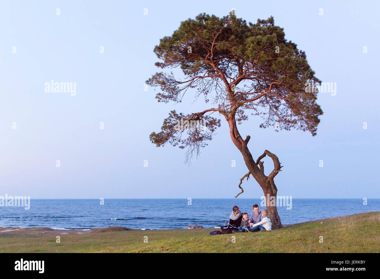 Father sitting with his children by the sea hi-res stock photography ...