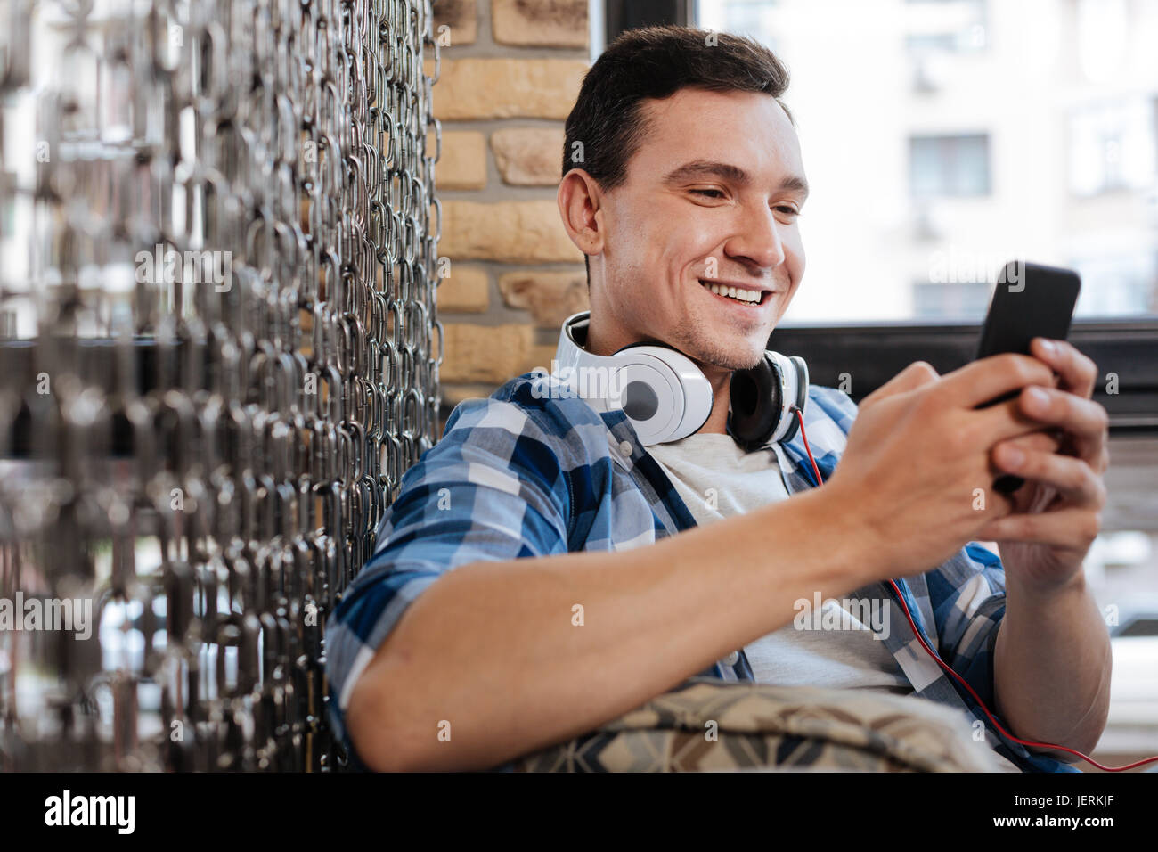 Energetic friendly guy using his gadget Stock Photo - Alamy