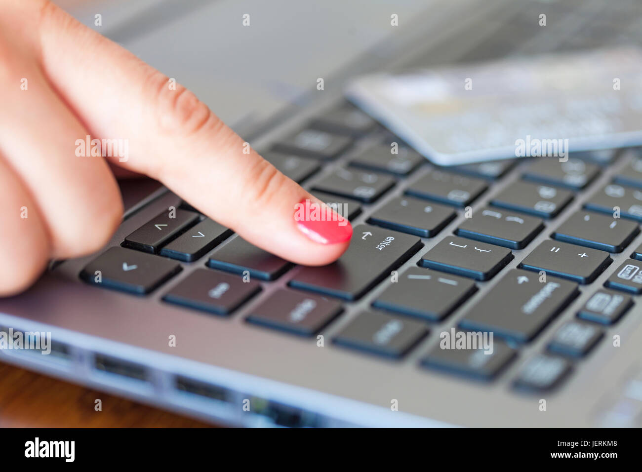 Finger pointing at Enter key, credit card lying on the keyboard ...