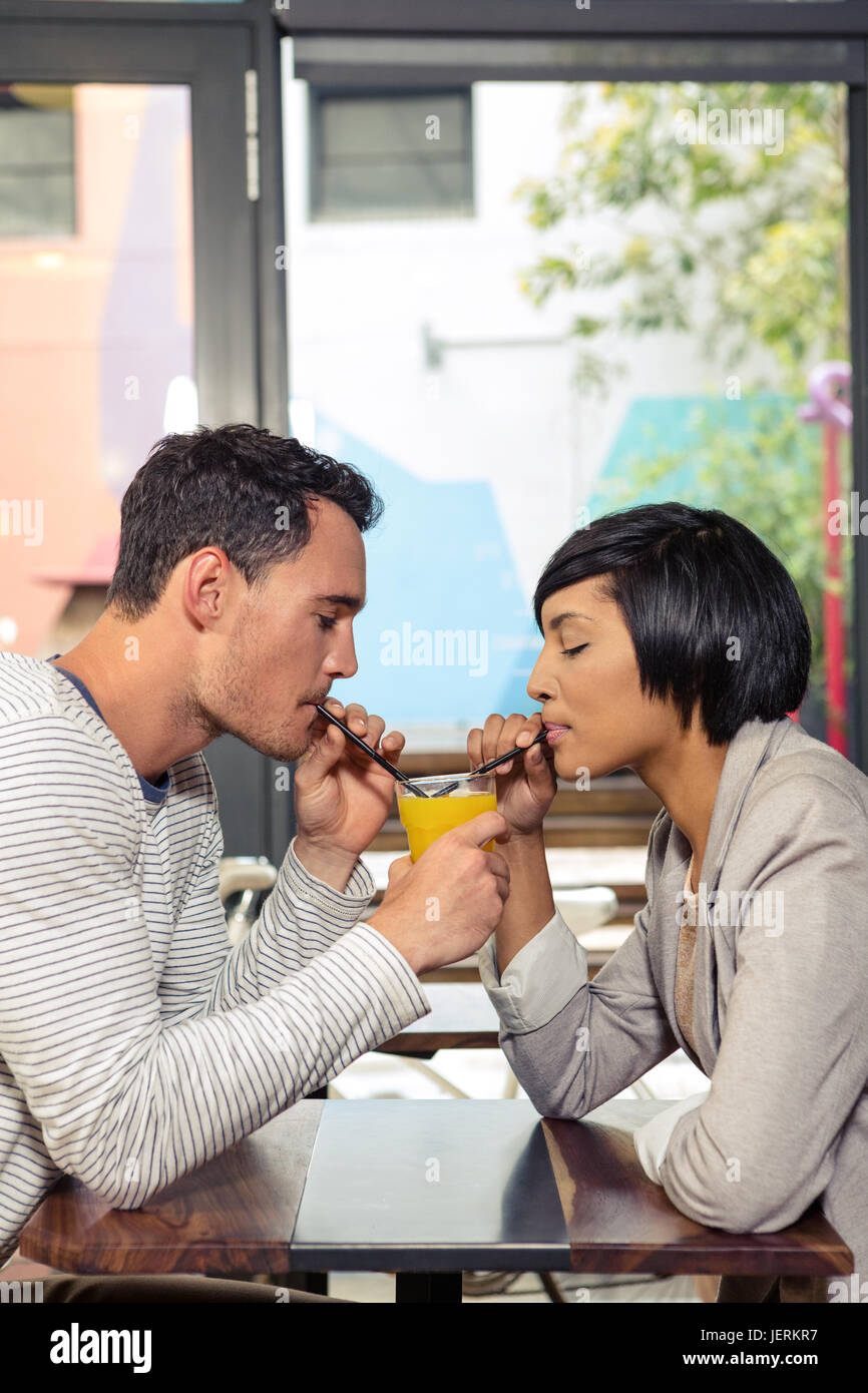 Cute couple drinking together orange juice Stock Photo - Alamy