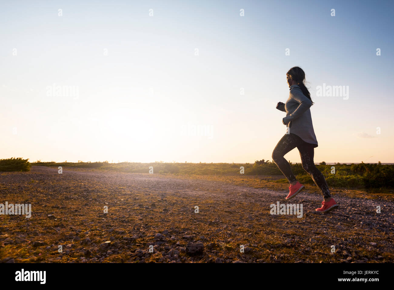 Woman running at evening Stock Photo - Alamy