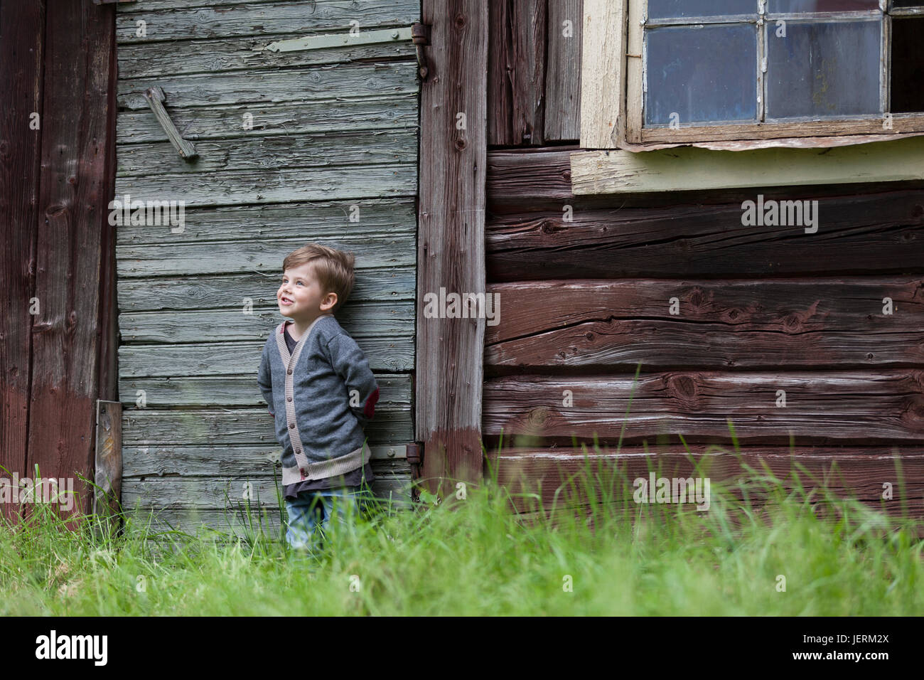 Boy standing near wooden house Stock Photo - Alamy