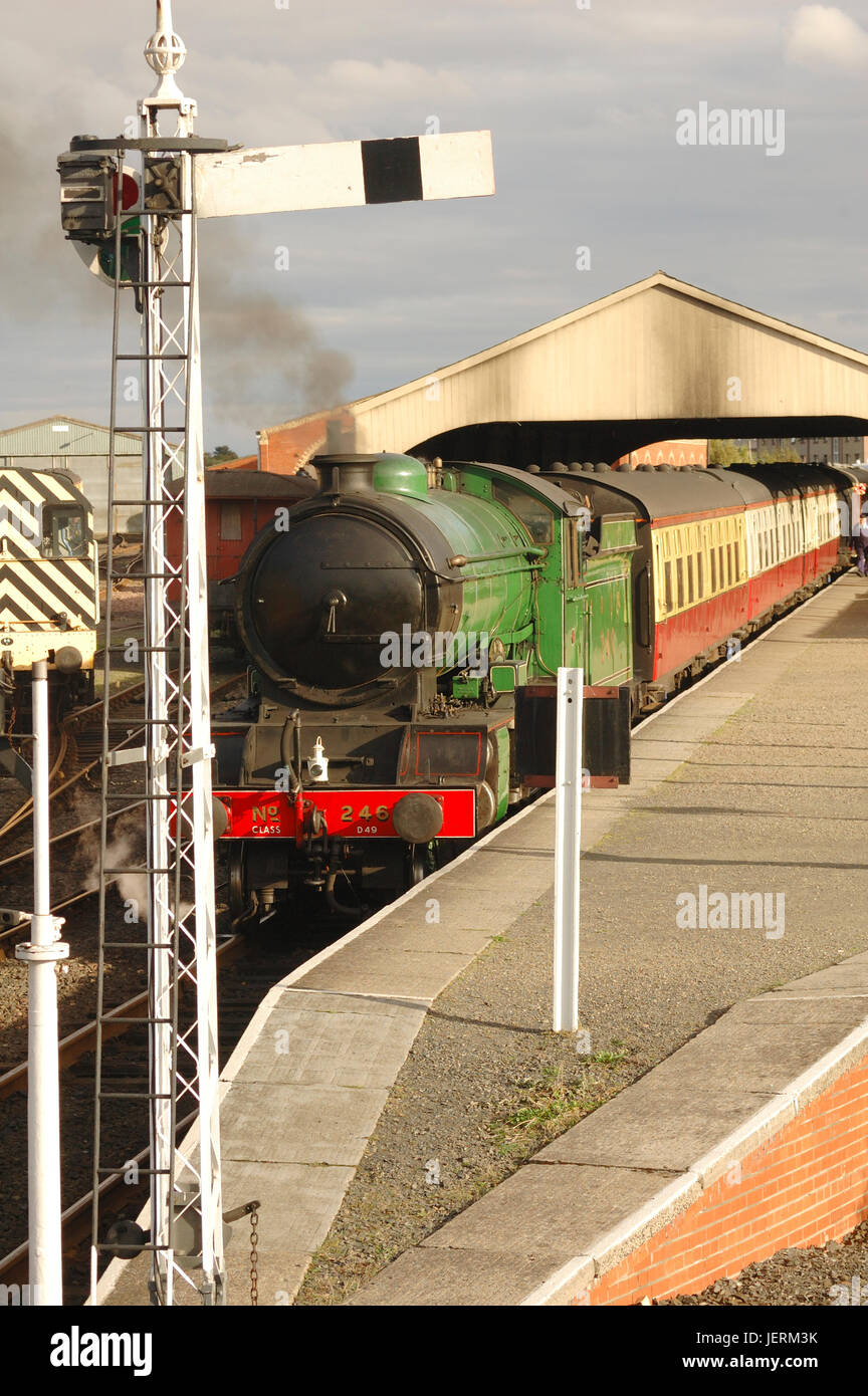 Caledonian steam train at old station platform with railway signal ...