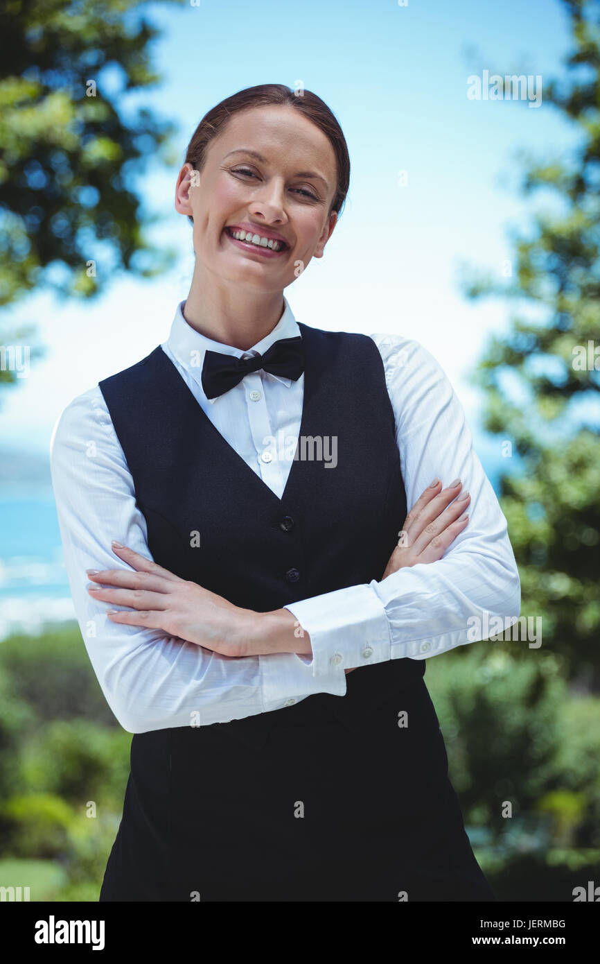 Smiling waitress posing with crossed arms Stock Photo - Alamy