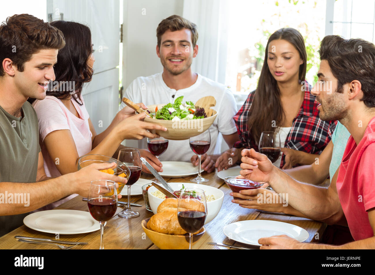 Happy friends having lunch at table Stock Photo - Alamy
