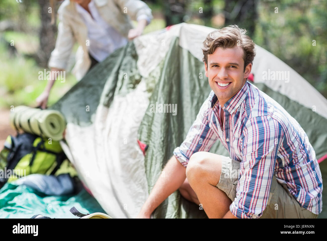 Portrait of man making tent with partner Stock Photo - Alamy