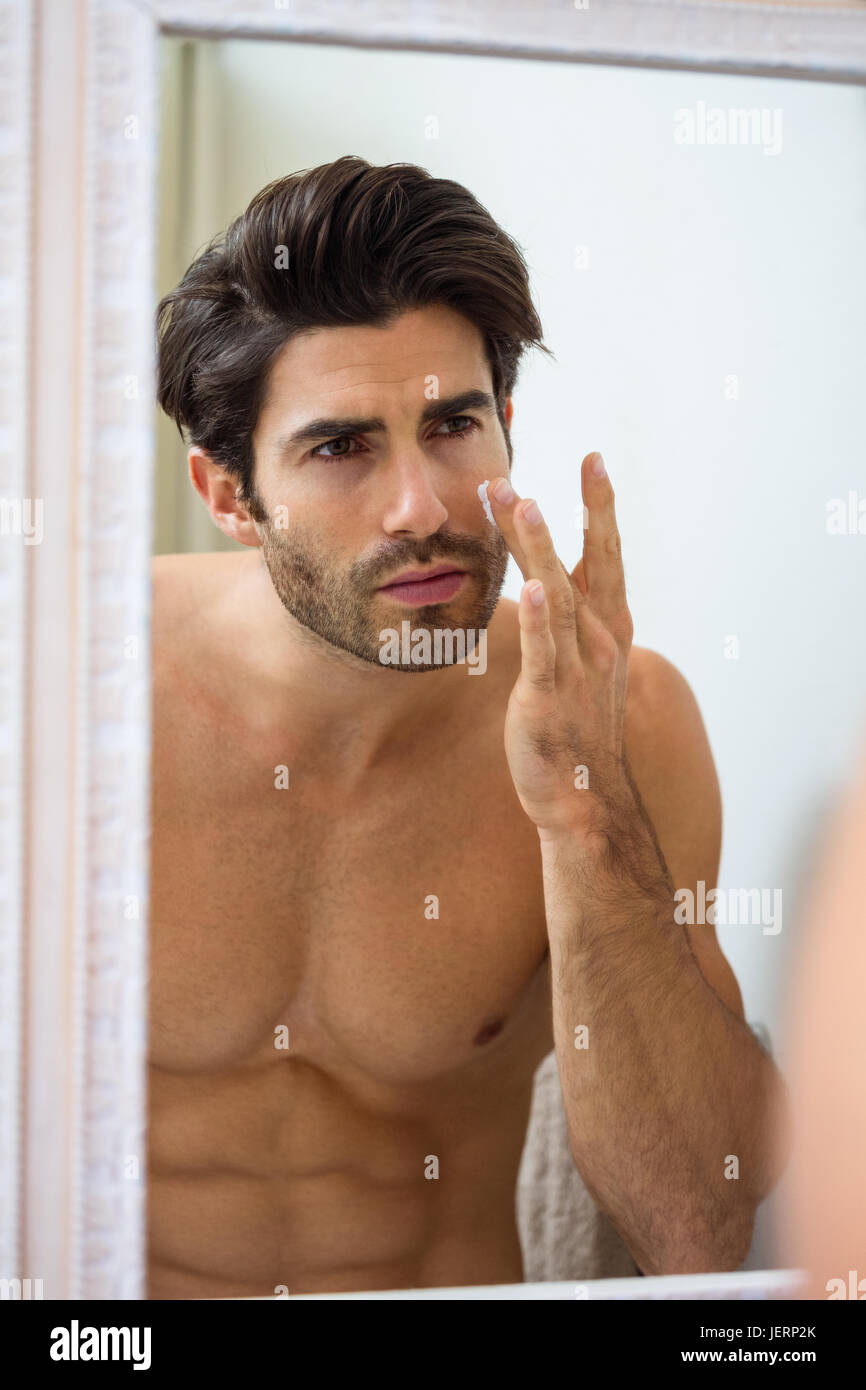 Man applying moisturizer on his face Stock Photo - Alamy