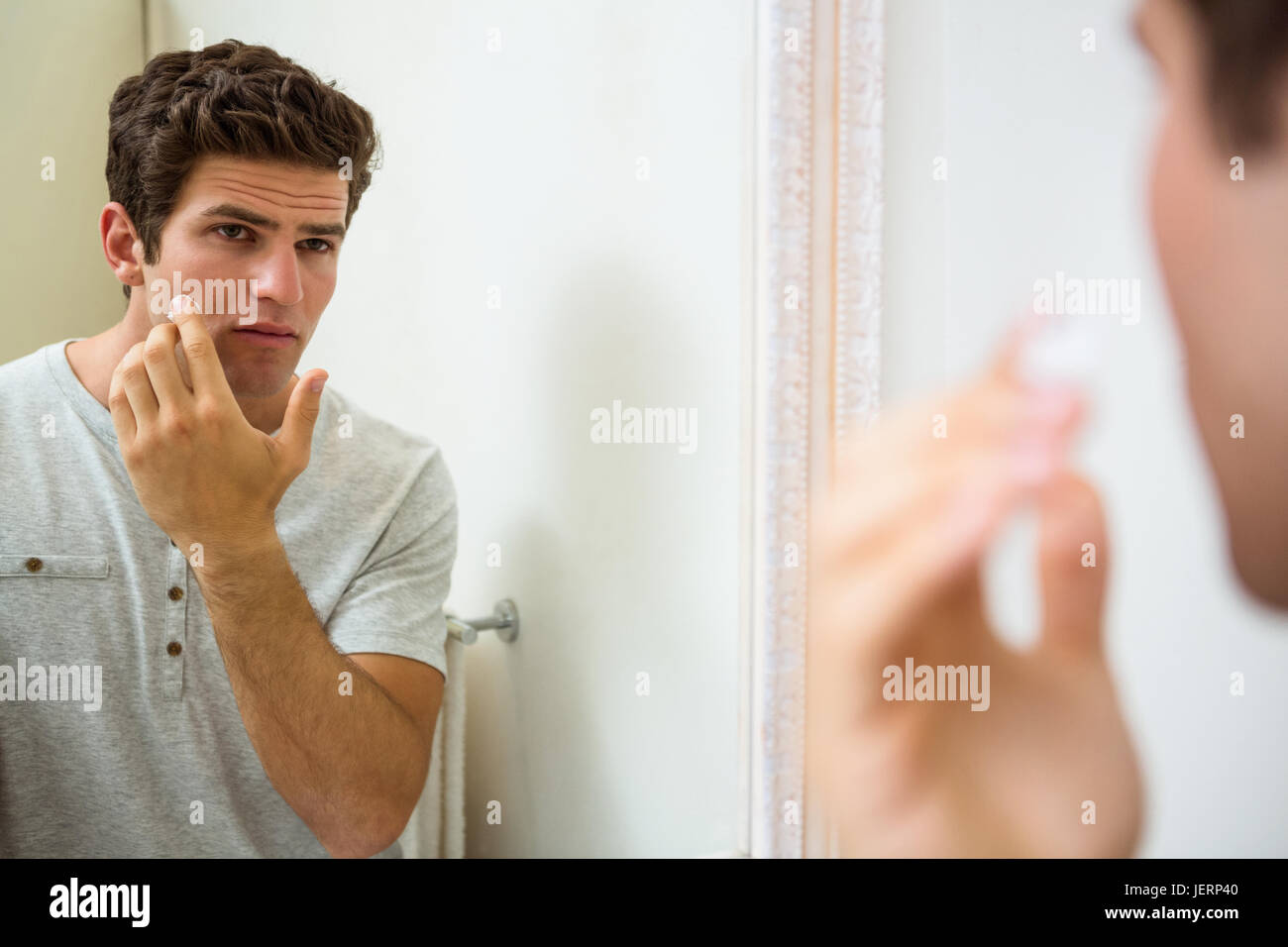 Man applying moisturizer on his face Stock Photo - Alamy