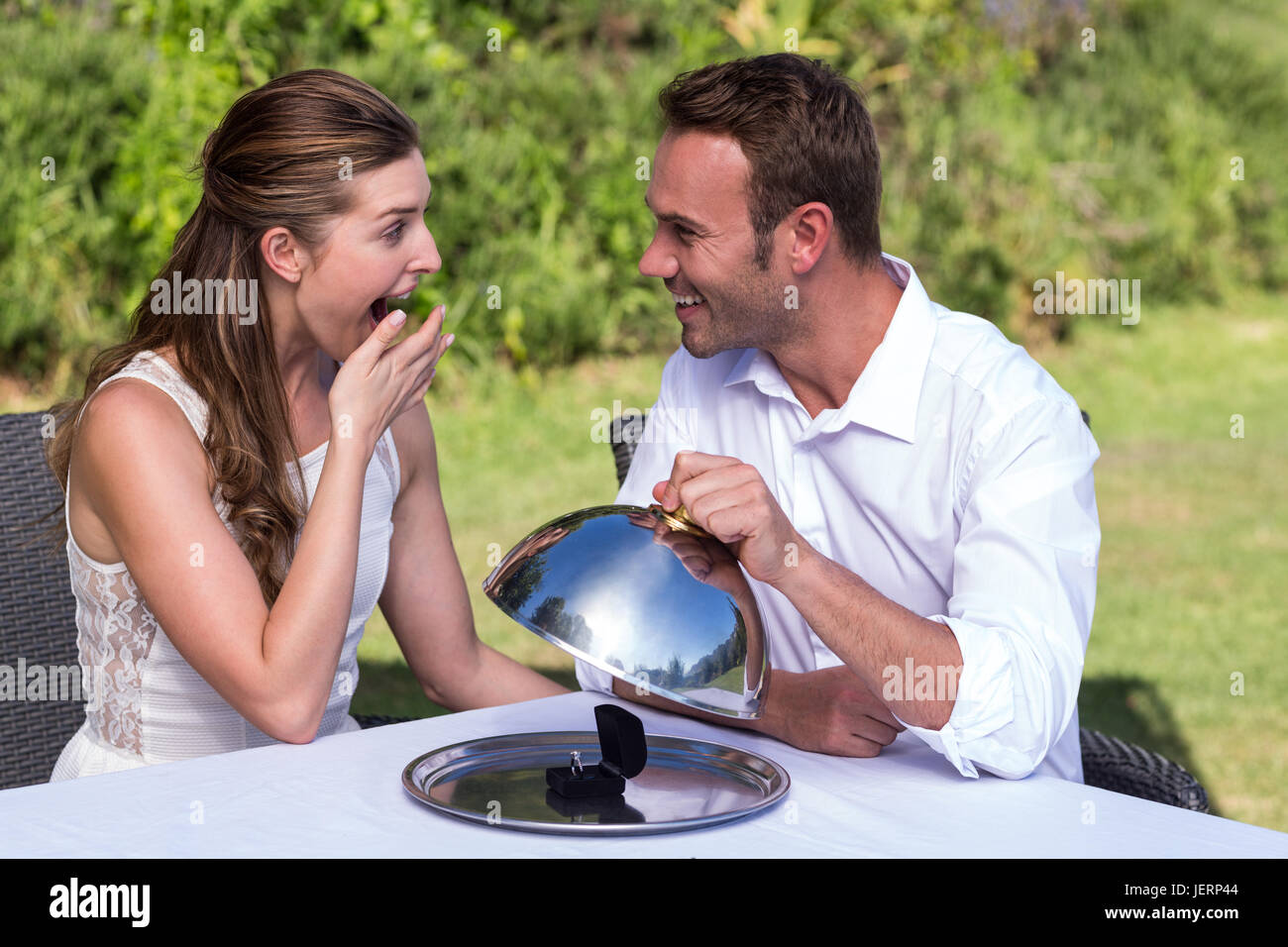 Man holding cloche while proposing woman Stock Photo - Alamy