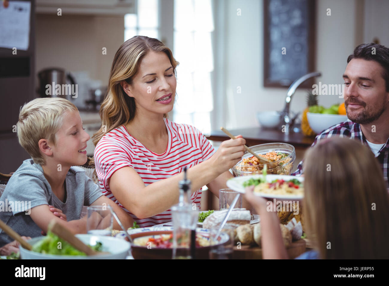 Parents and children sitting at dining table Stock Photo - Alamy