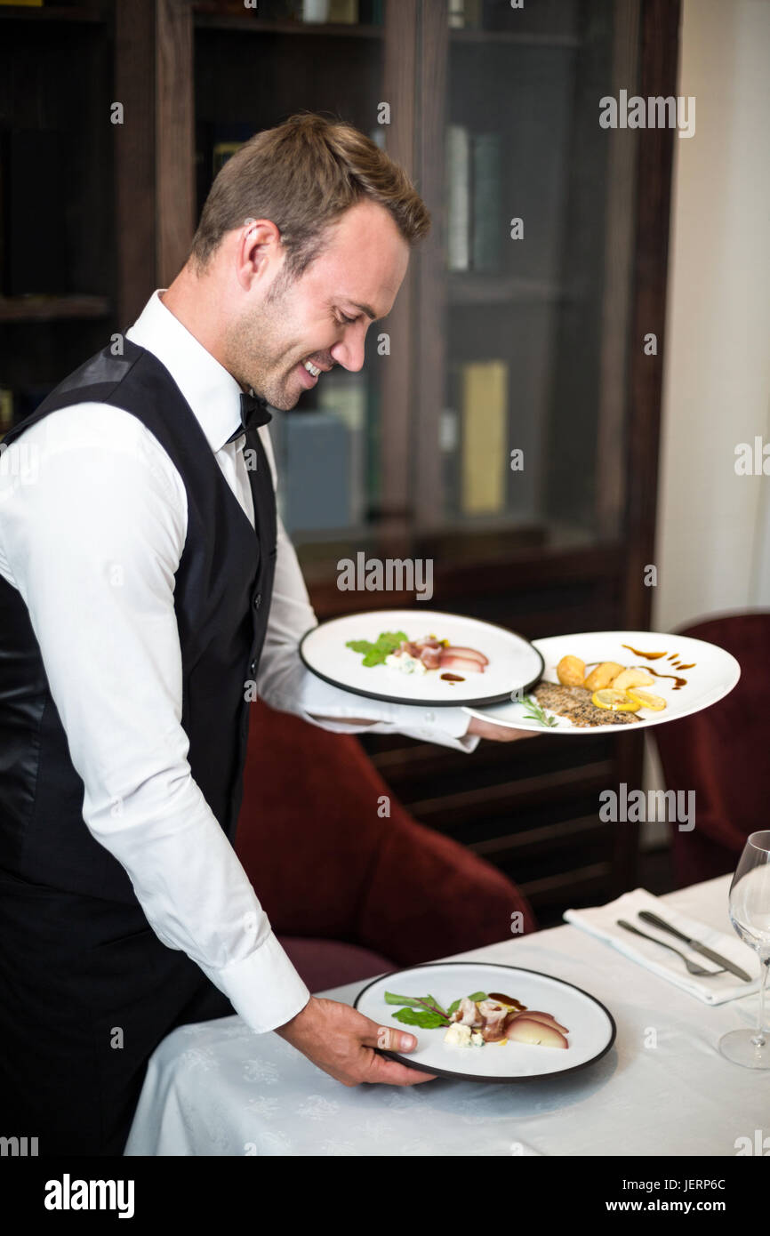 Handsome waiter serving meal Stock Photo - Alamy