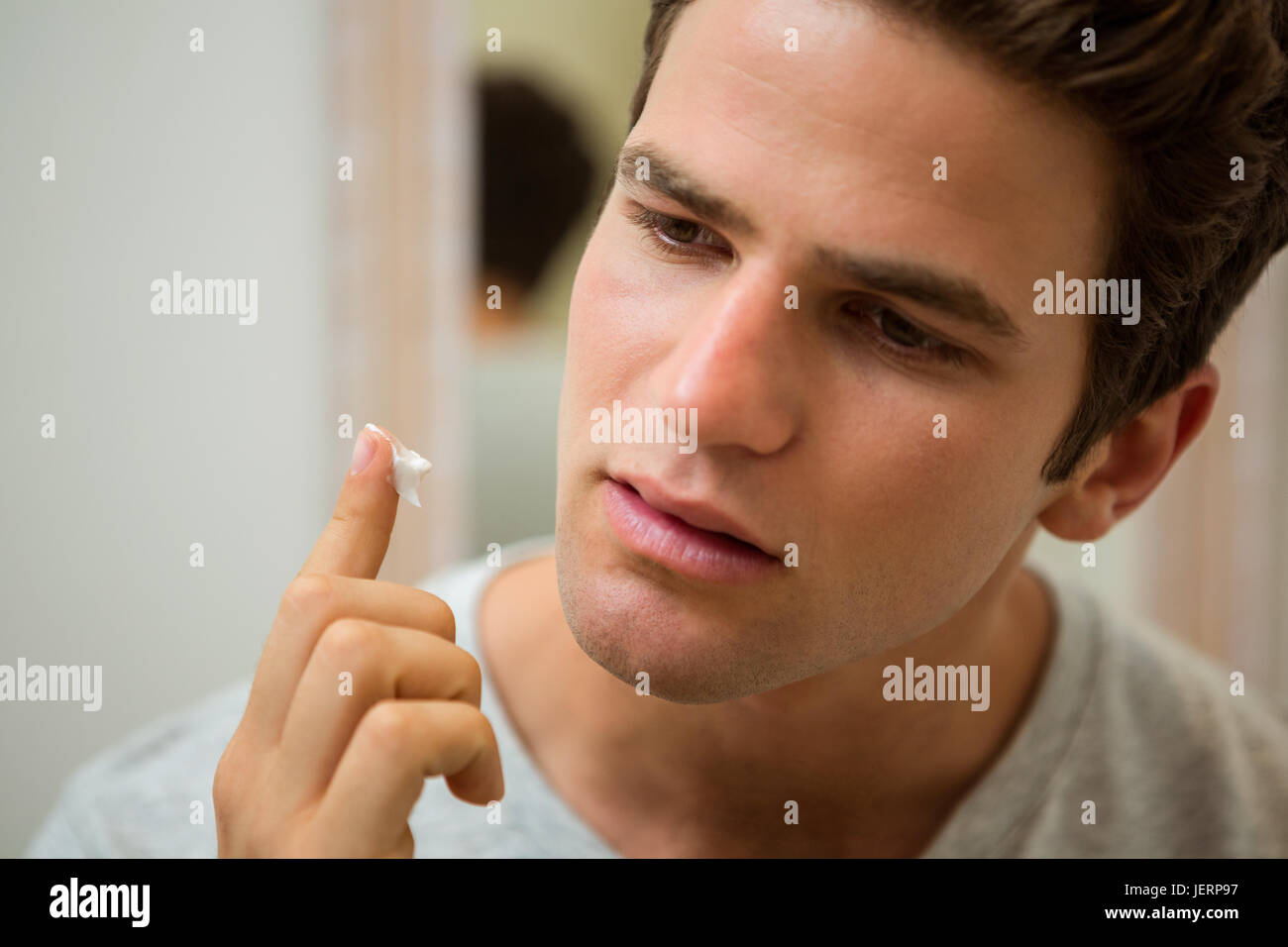 Man applying moisturizer on his face Stock Photo - Alamy