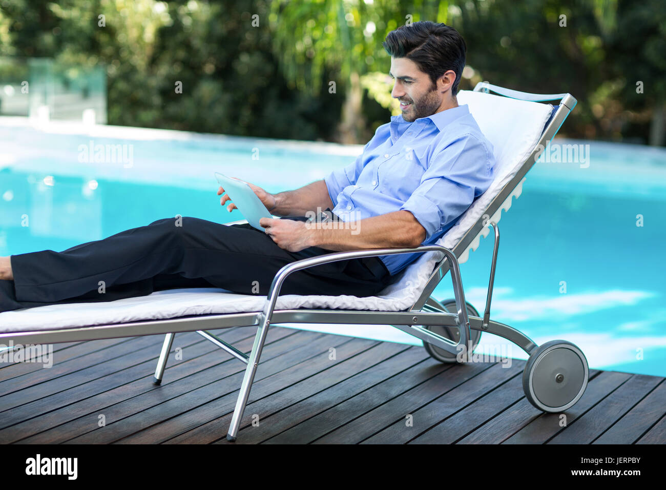 Smart man using digital tablet near pool Stock Photo - Alamy